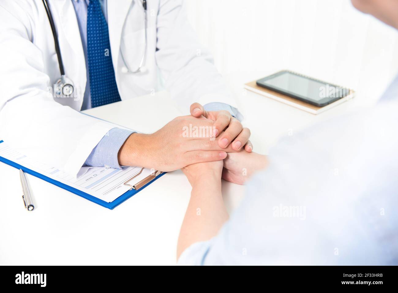 Doctor holding patient hands with care Stock Photo - Alamy