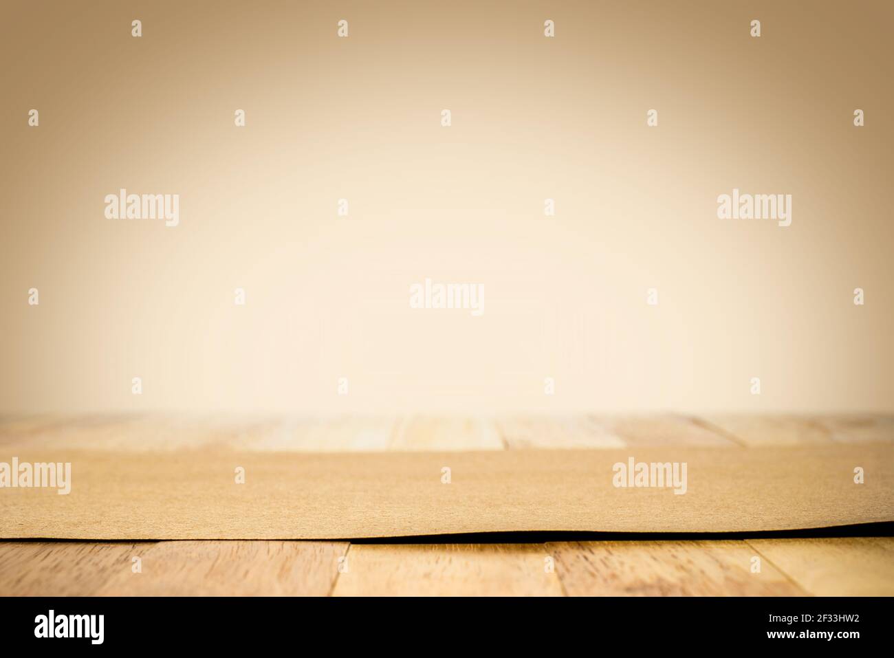 Brown paper on wood table top in light brown gradient background - can ...