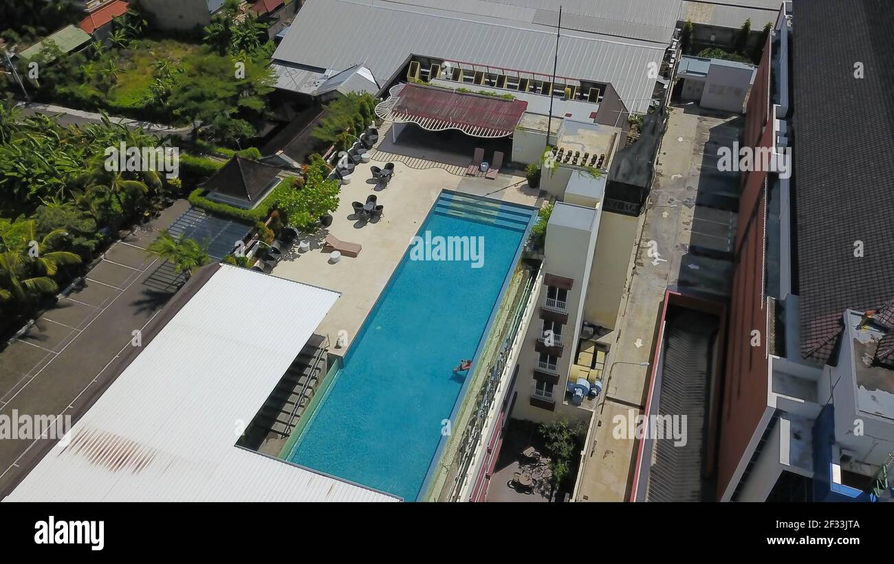 Aerial footage of a man in the pool on the roof of luxury hotel, Kuta ...