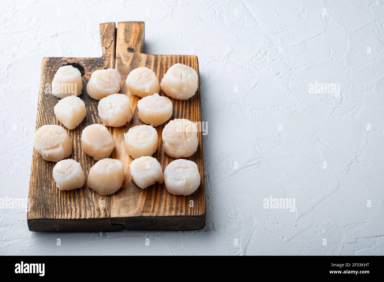 Raw uncooked scallops set, on white textured background with space for ...
