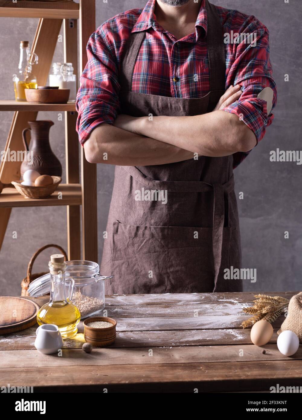 Baker man and bakery ingredients for homemade bread cooking on table ...