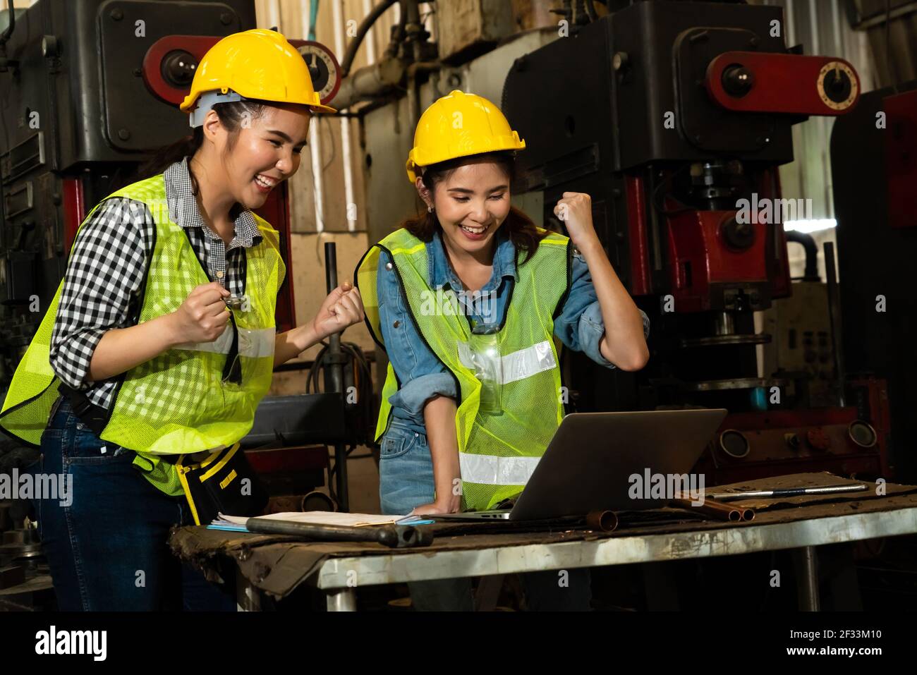 Two factory job worker celebrate success together in the manufacturing ...