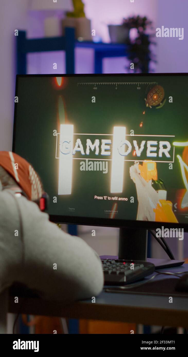 Game over for sad gamer playing shooter video games on powerful ...
