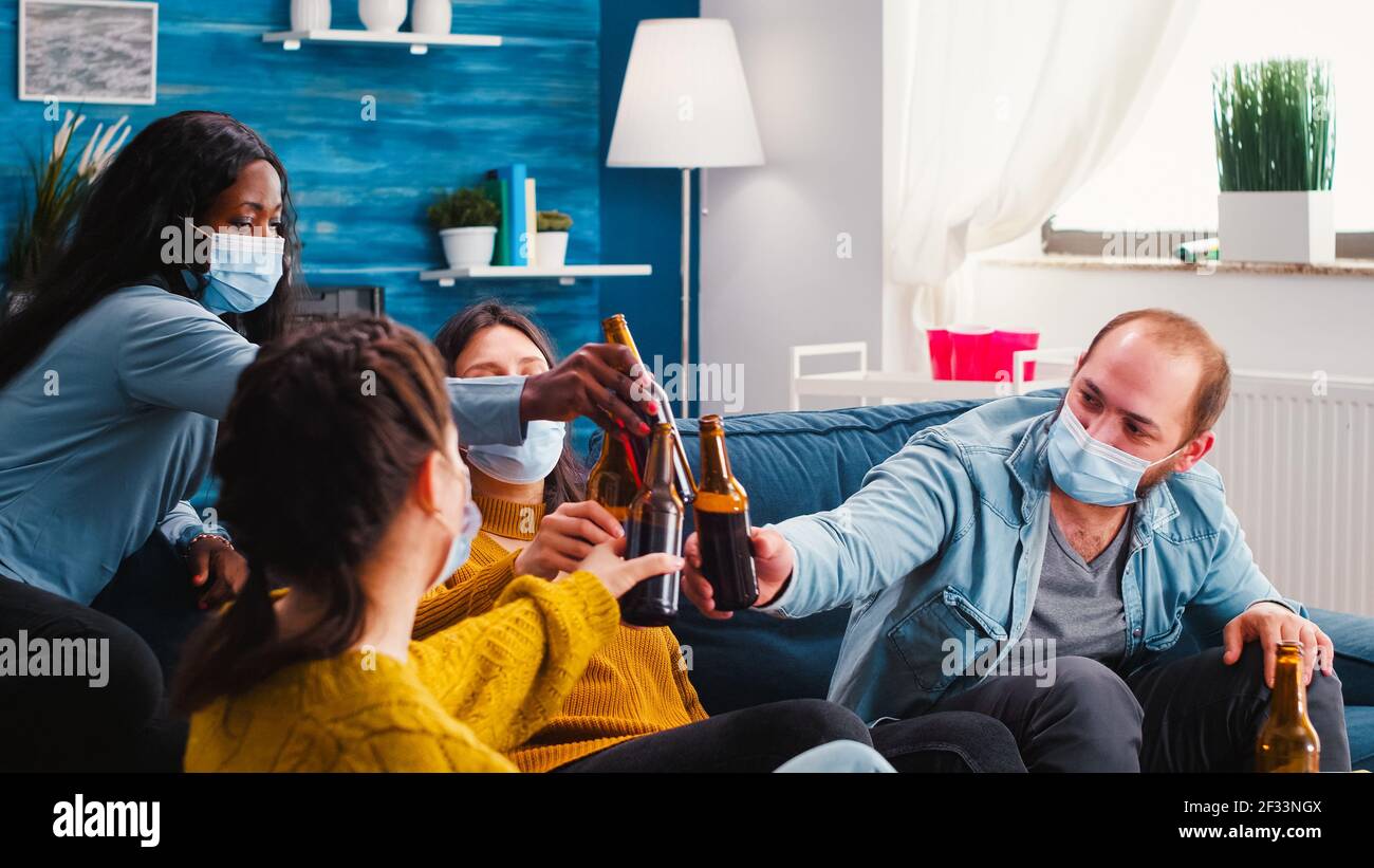 Young people toasting and cheering bottles of beer spending free time ...