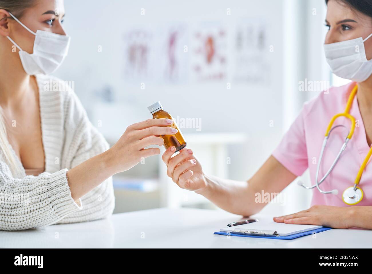 Doctor in mask explaining diagnosis to her female patient Stock Photo ...