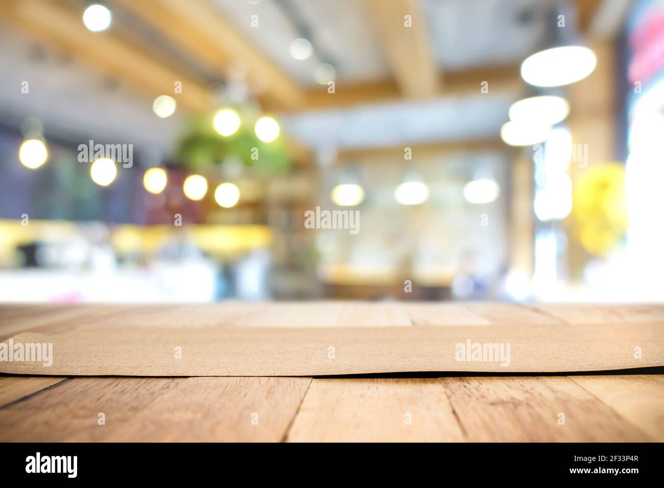 Brown paper on wood table top in blur cafe interior background - can be ...