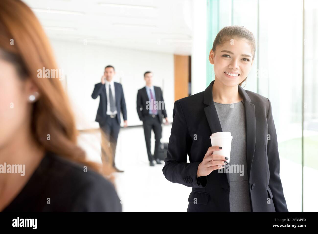 Business people walking in building hallway Stock Photo - Alamy