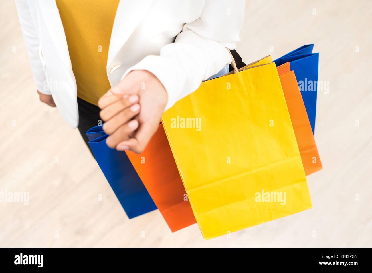Woman arm carrying colorful paper shopping bags Stock Photo - Alamy