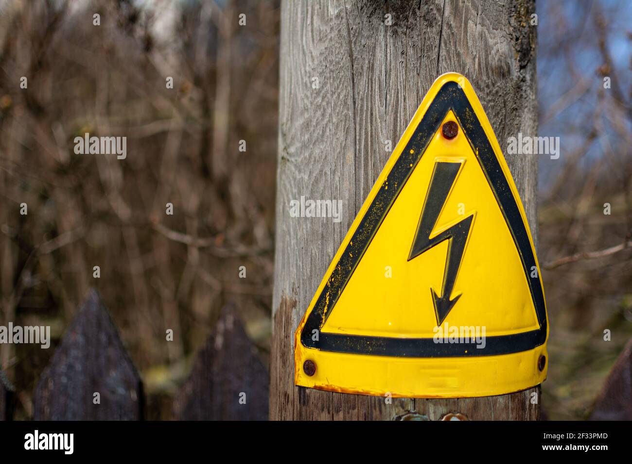 Sign at the bottom of a wooden electrical pole warning of the danger of ...