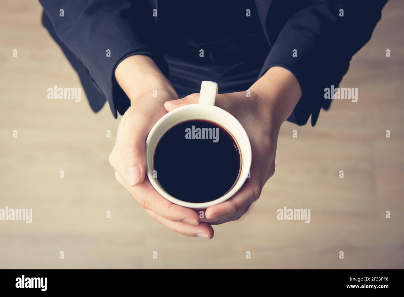 Woman hands holding coffee cup with black coffee - top view, vintage ...