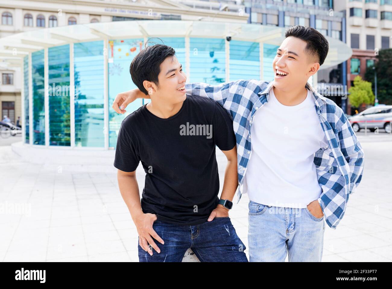 Two Asian friends having fun together in the city during summer ...