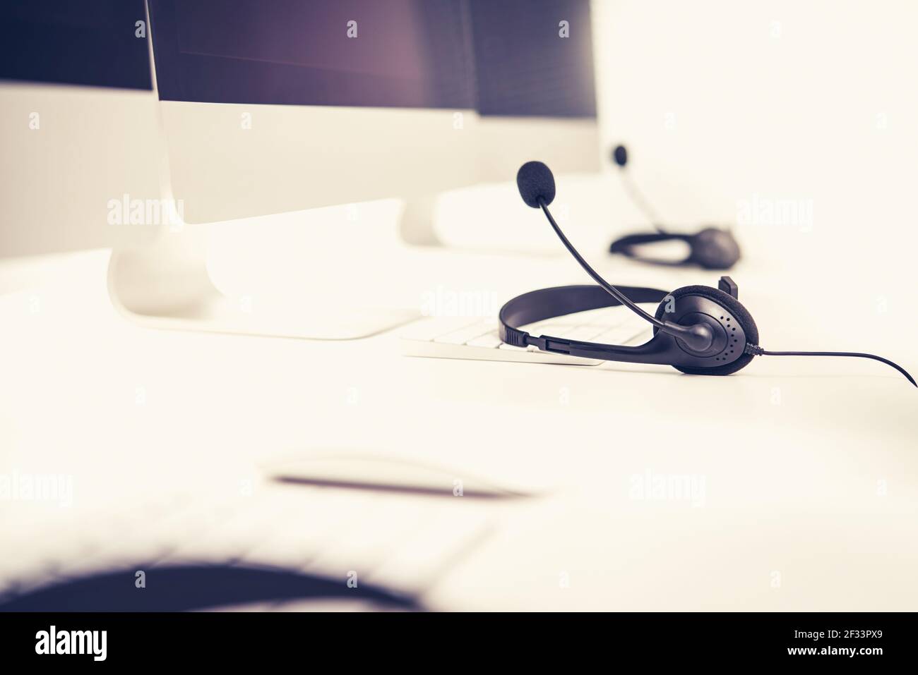 Microphone headsets on the table with computer keyboard, vintage tone ...