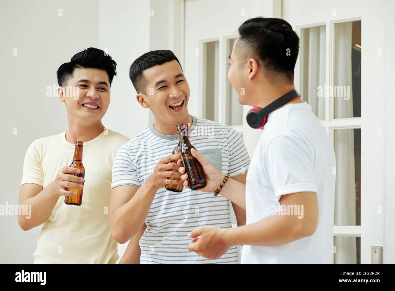 Group of Asian men having fun together while drinking beer at home ...