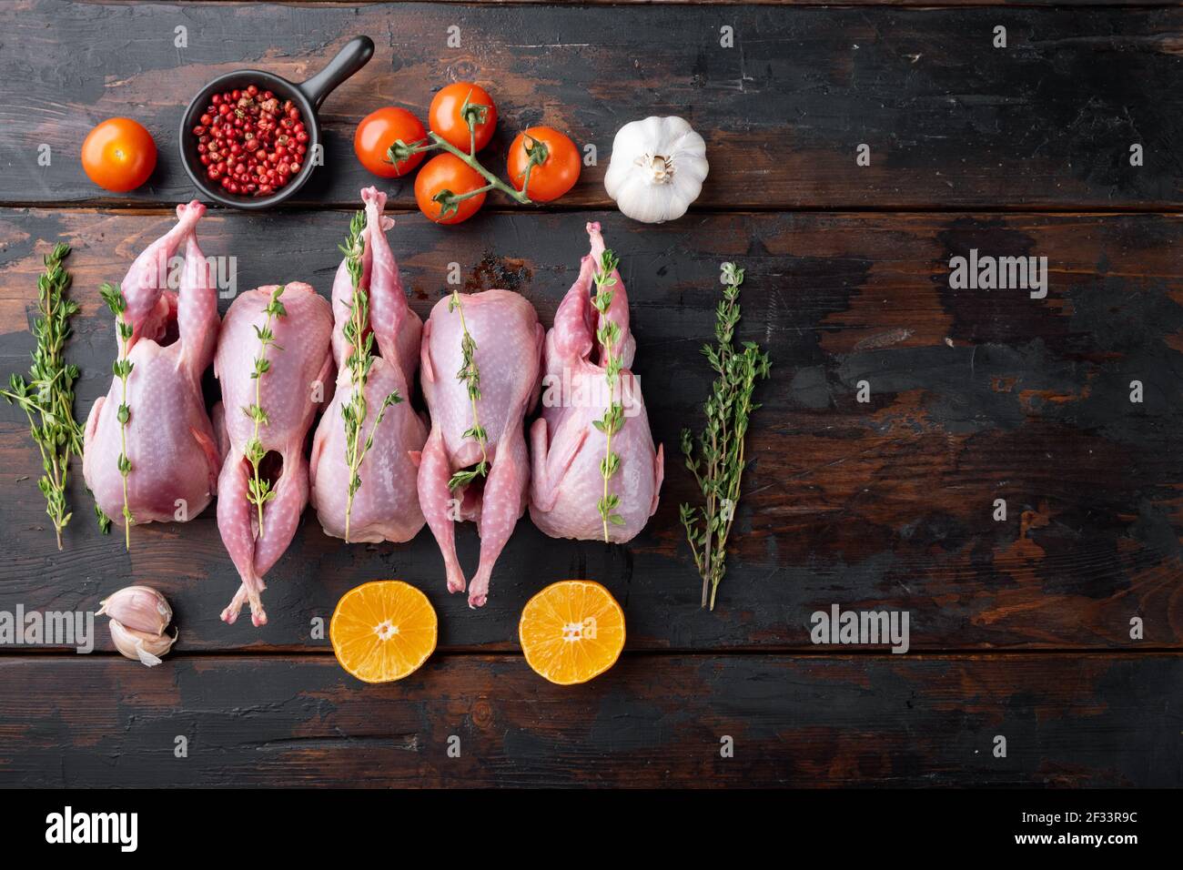 Fresh raw meat quails with herb, flat lay, on dark wooden background ...