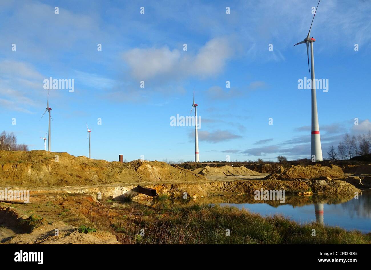 Wind turbines beside a sand excavation. The reflection of one of the ...