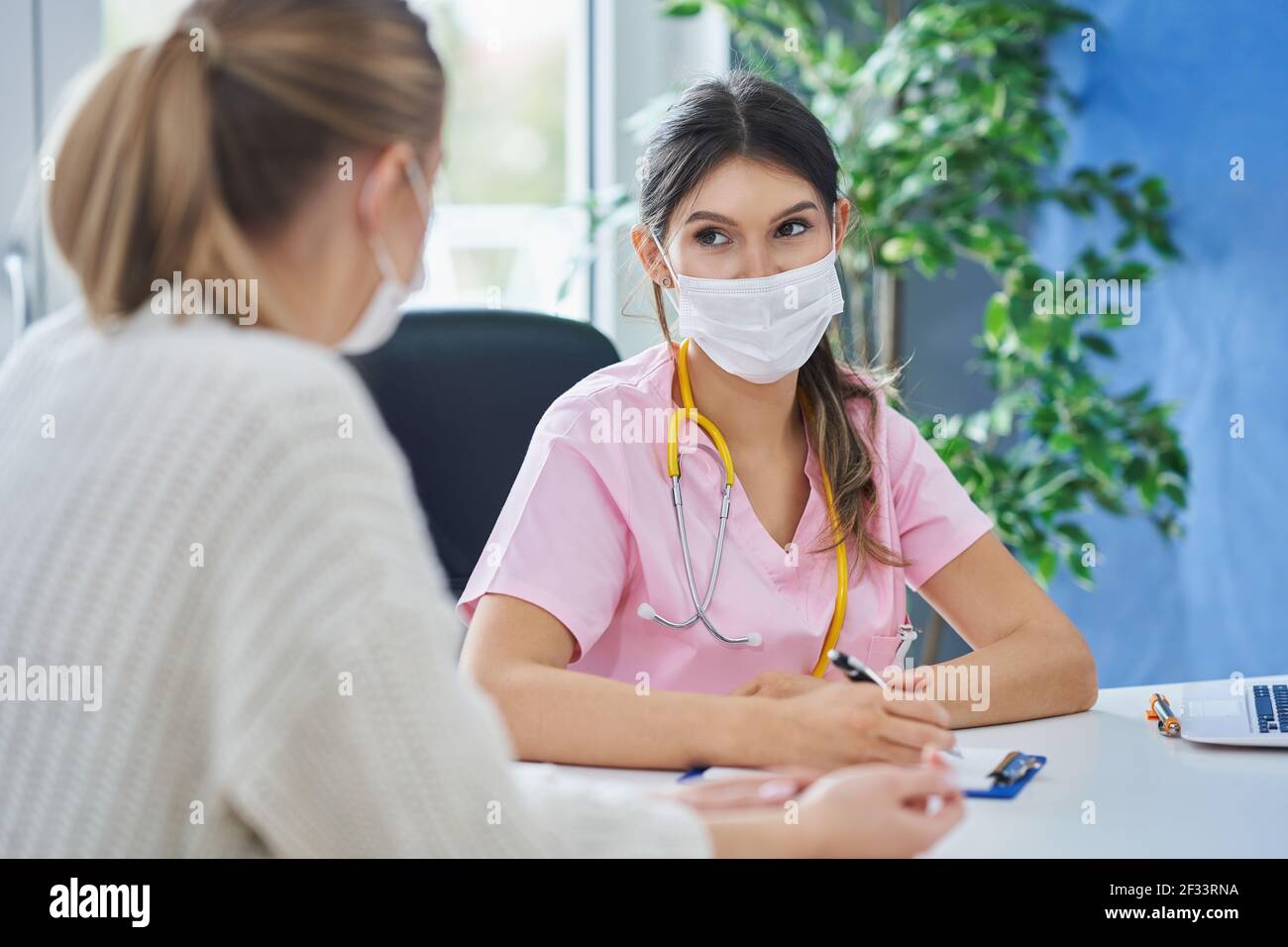 Doctor in mask explaining diagnosis to her female patient Stock Photo ...
