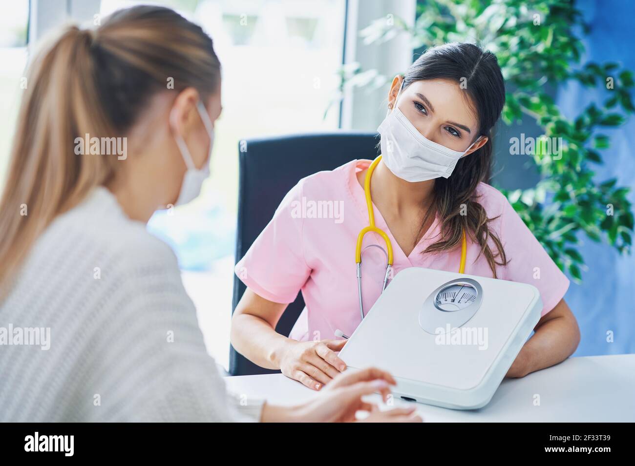 Doctor in mask explaining diagnosis to her female patient Stock Photo ...
