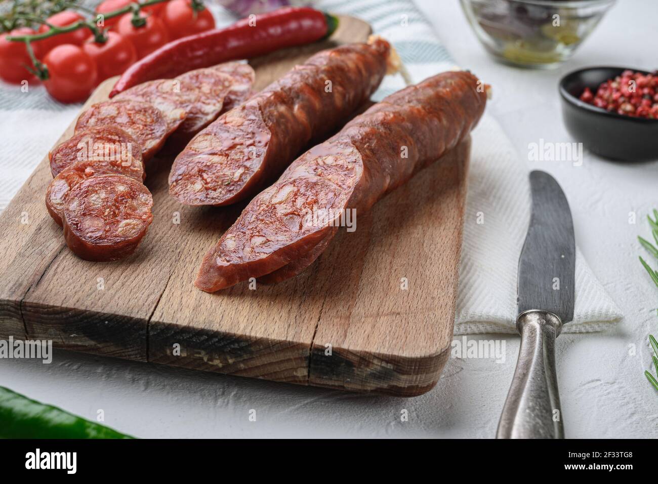 Traditional chorizo cuts with spices and ingredients on white surface ...