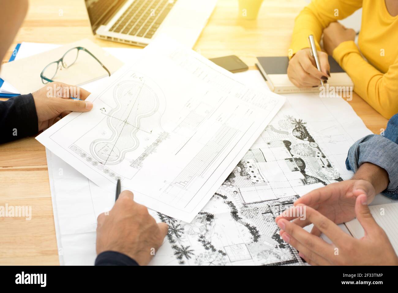 Architects (or landscape designers) discussing blueprints in the ...