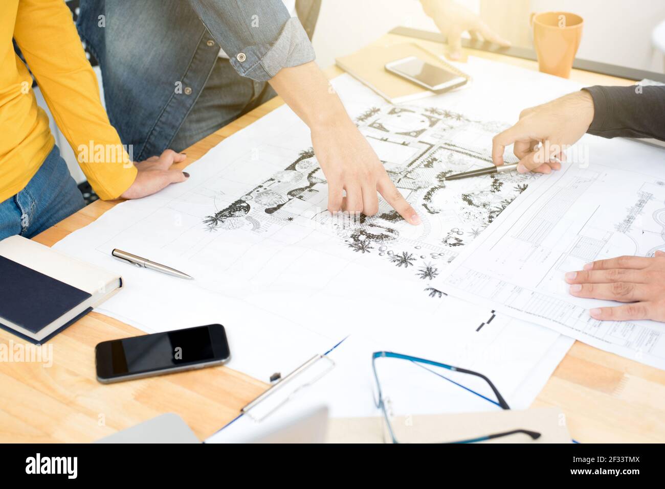 Architects (landscape designers) discussing blueprints in the meeting ...