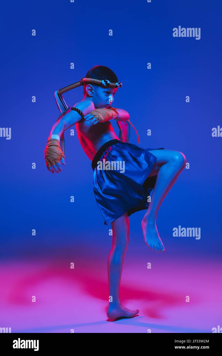 Young boy thai boxer training over blue background in neon light Stock ...