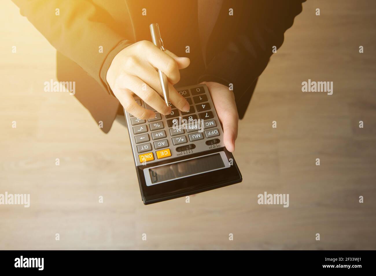 Businesswoman hand pressing calculator, top view Stock Photo - Alamy