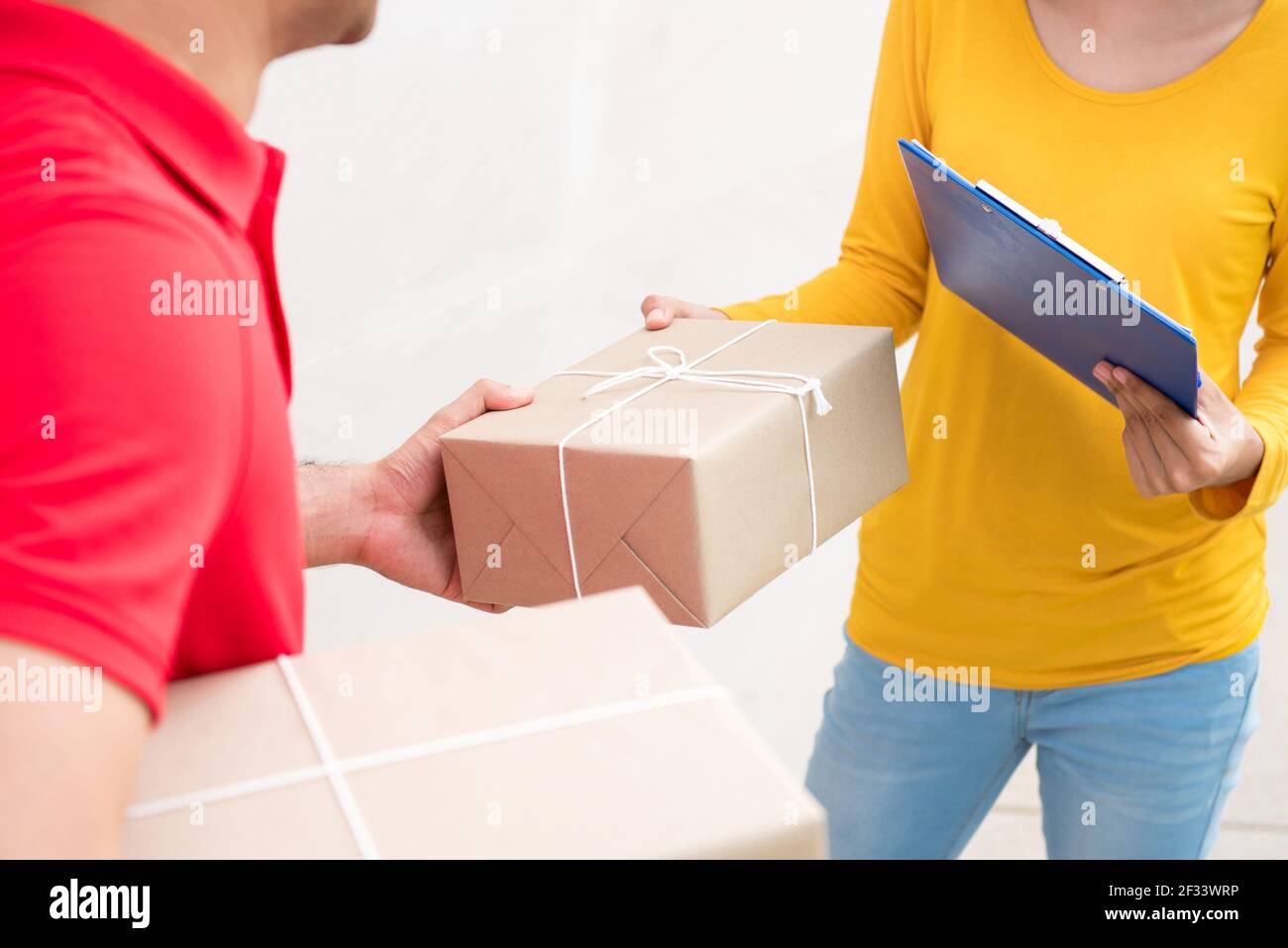 Delivery man giving parcel box to a woman Stock Photo - Alamy