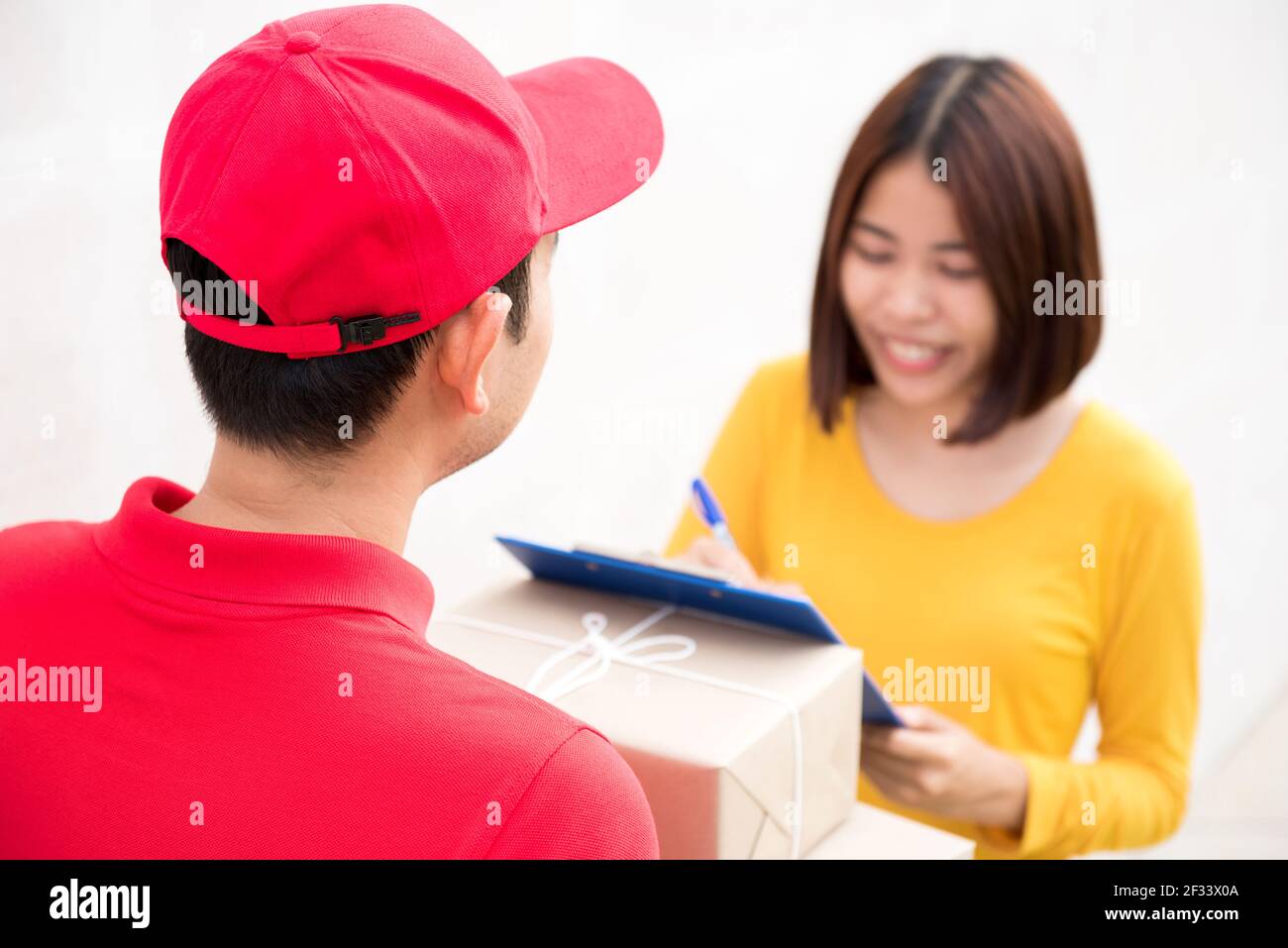 Postal delivery man delivering parcel boxes to a woman Stock Photo - Alamy