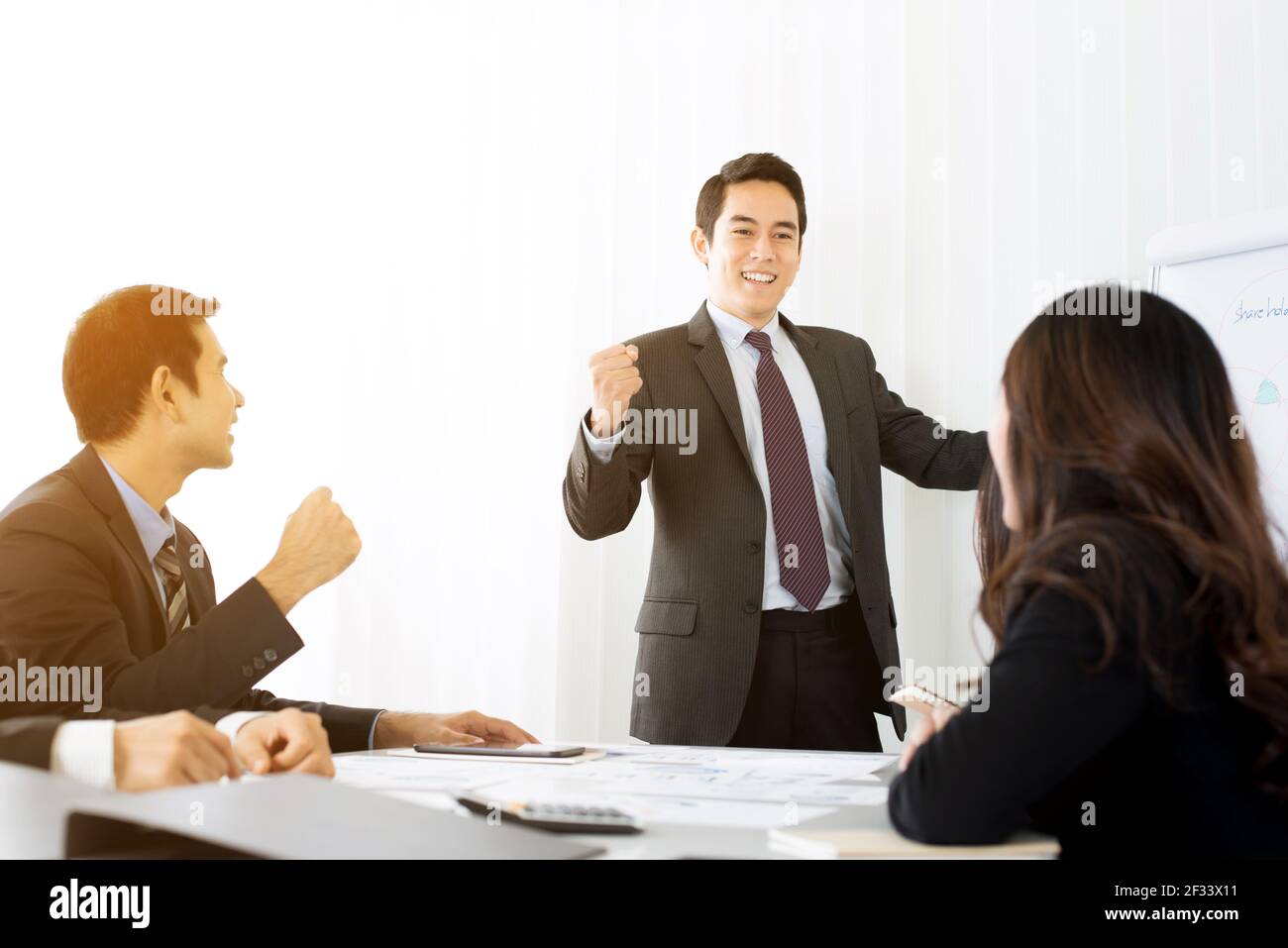 Powerful businessman clenching his fist empowering his colleagues in ...