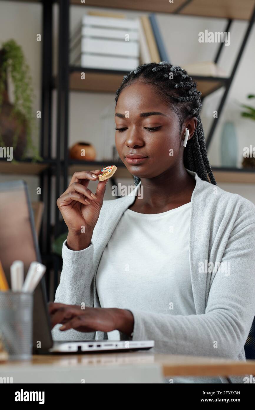 Pretty Young Black Woman With Braided Hair Eating Homemade Sugar Cooke