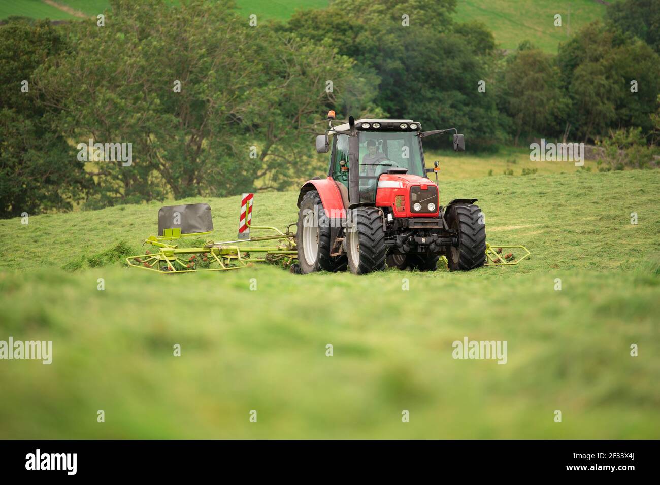 Tractor mowing and cutting the hay silage Stock Photo - Alamy