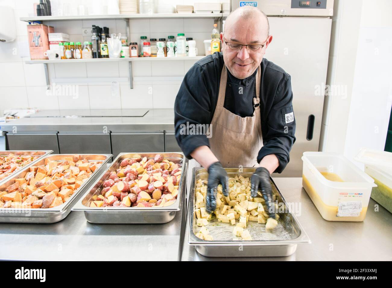 Tilburg, Netherlands. Mid adult male chef preparing healthy take away ...