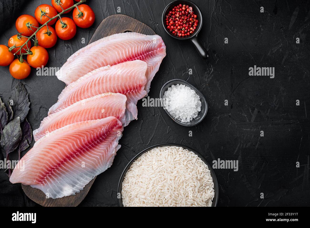 Raw white fish tilapia, with basmati rice and cherry tomatoes ...