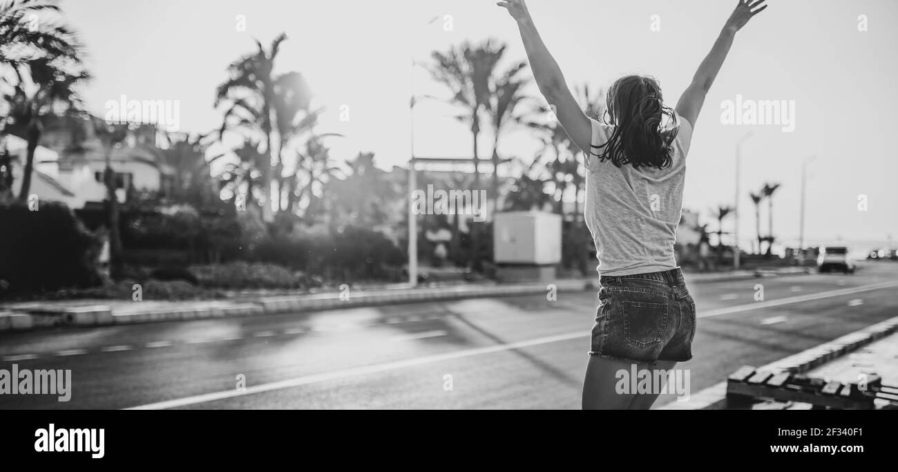 Black and white photo of a young girl in shorts in a jump in the summer ...