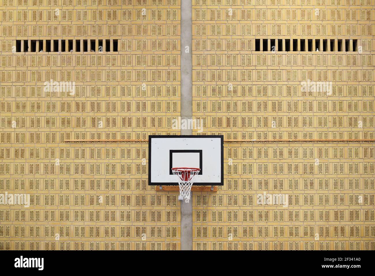 Basketball hoop hanging on school building exterior Stock Photo - Alamy