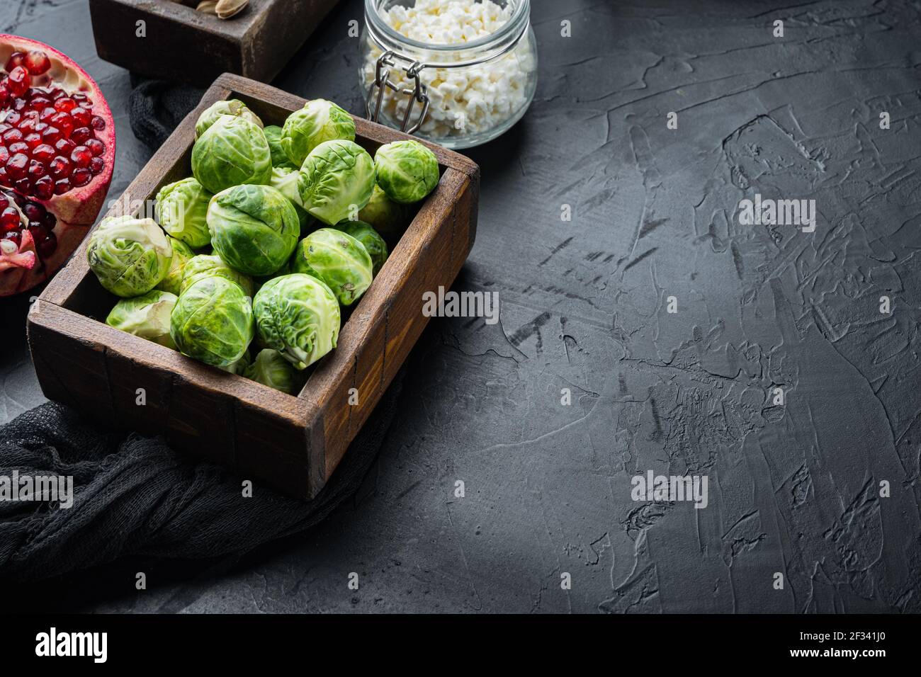 Gnarly garlic brussels ingredient, on black textured background with ...