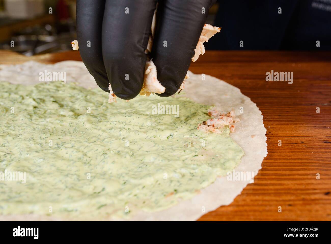 Burrito cooking process. Cook adds meat to pita with sauce. The process ...