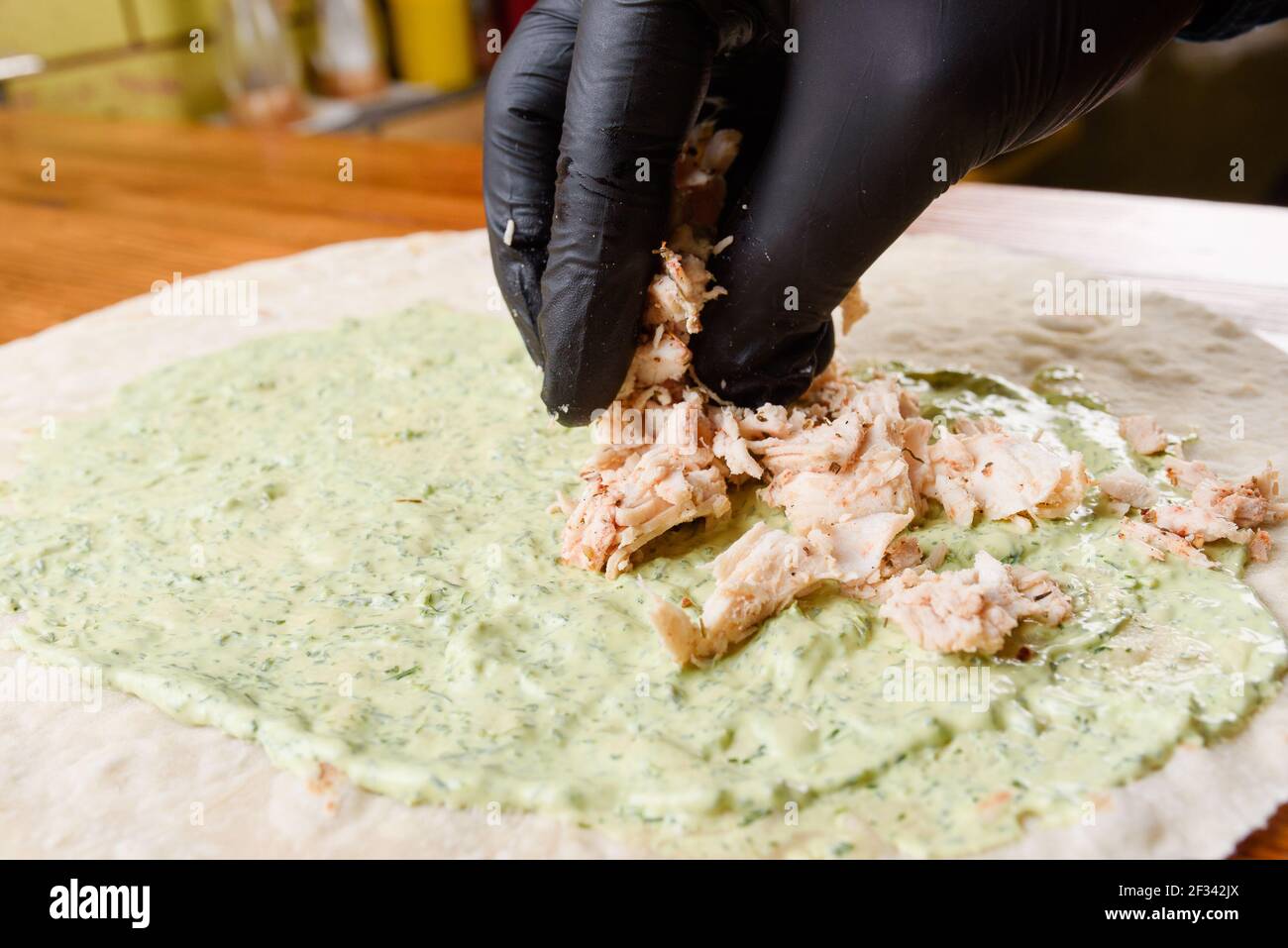 Burrito cooking process. Cook adds meat to pita with sauce. The process ...