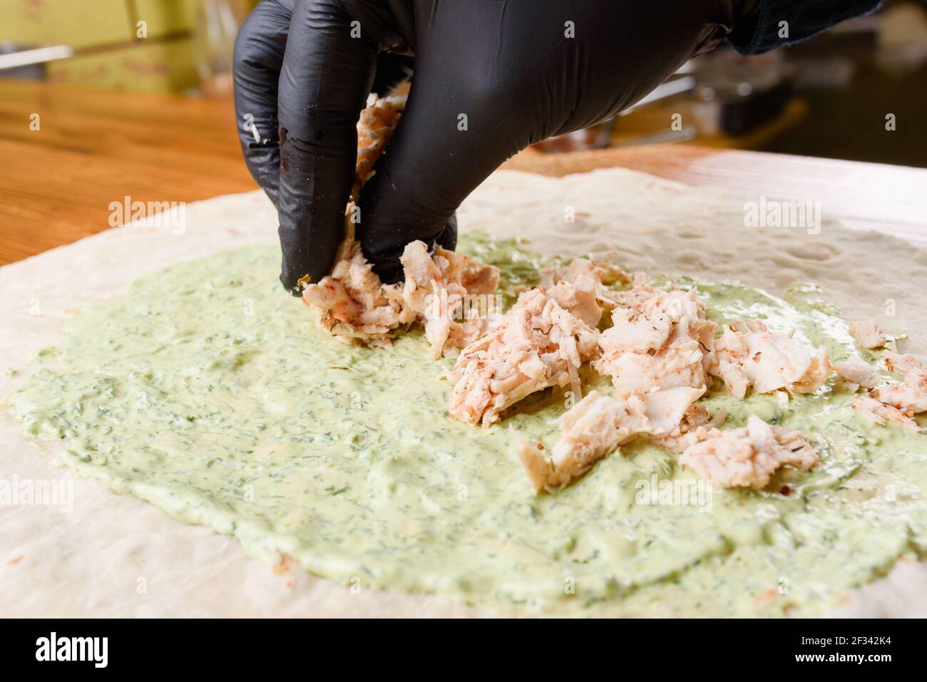 Burrito cooking process. Cook adds meat to pita with sauce. The process ...