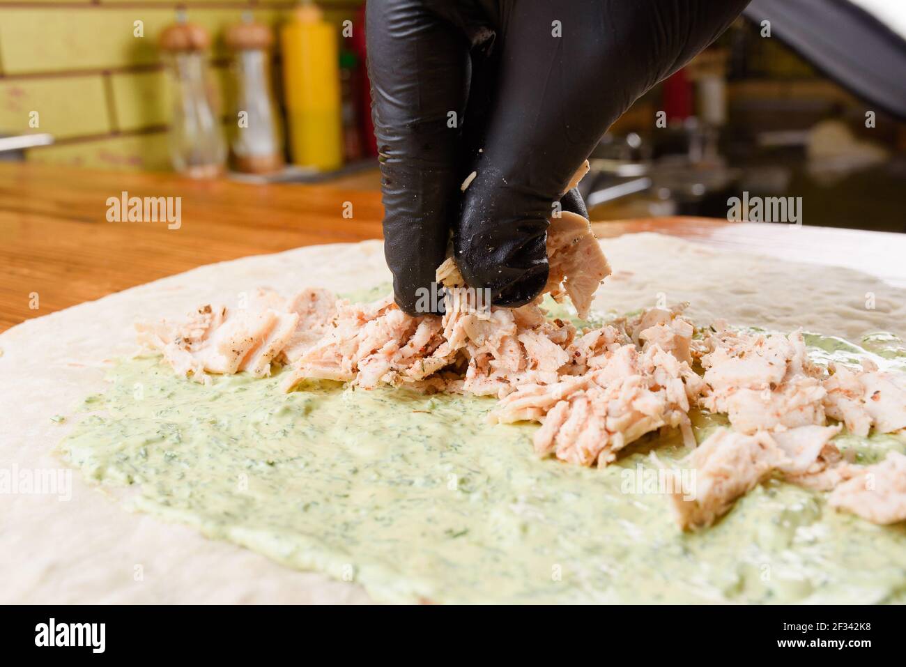 Burrito cooking process. Cook adds meat to pita with sauce. The process ...