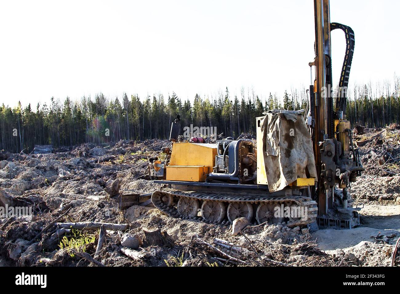 Mini-drilling rig on crawler track on site of sawn forest where large ...