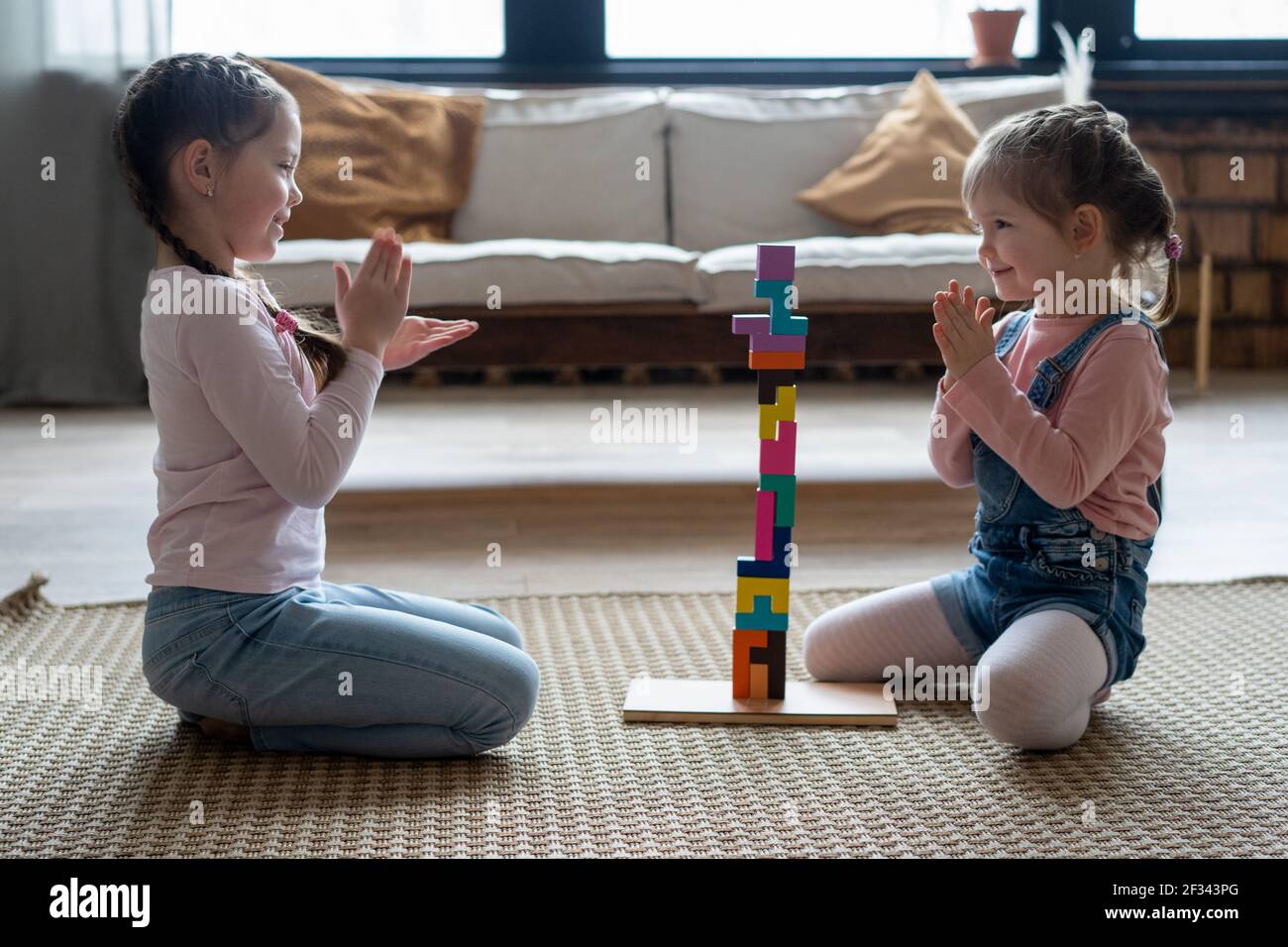 Kids playing with wooden blocks laying on the floor in their room Stock ...
