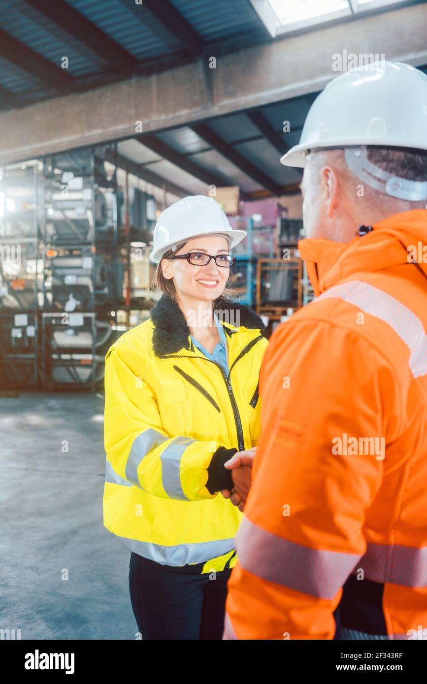 worker and customer in warehouse doing Handshake Stock Photo - Alamy