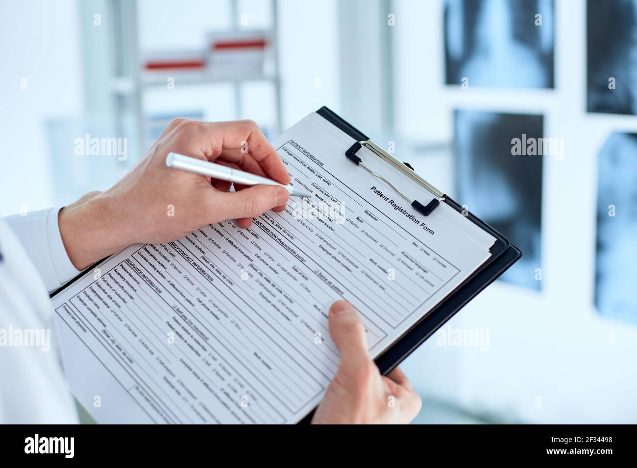 doctor is filling out the patient's registration form Stock Photo - Alamy
