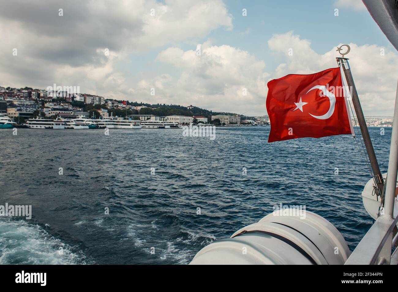 Turkish flag on ship in sea with seafront at background, Istanbul ...