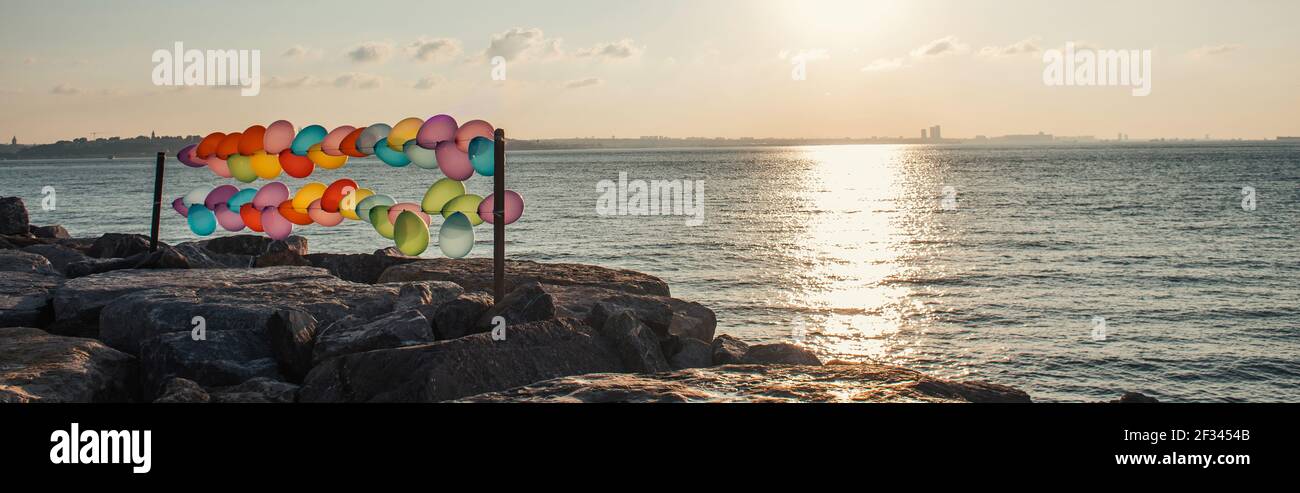Balloons on seafront during sunset, banner Stock Photo - Alamy