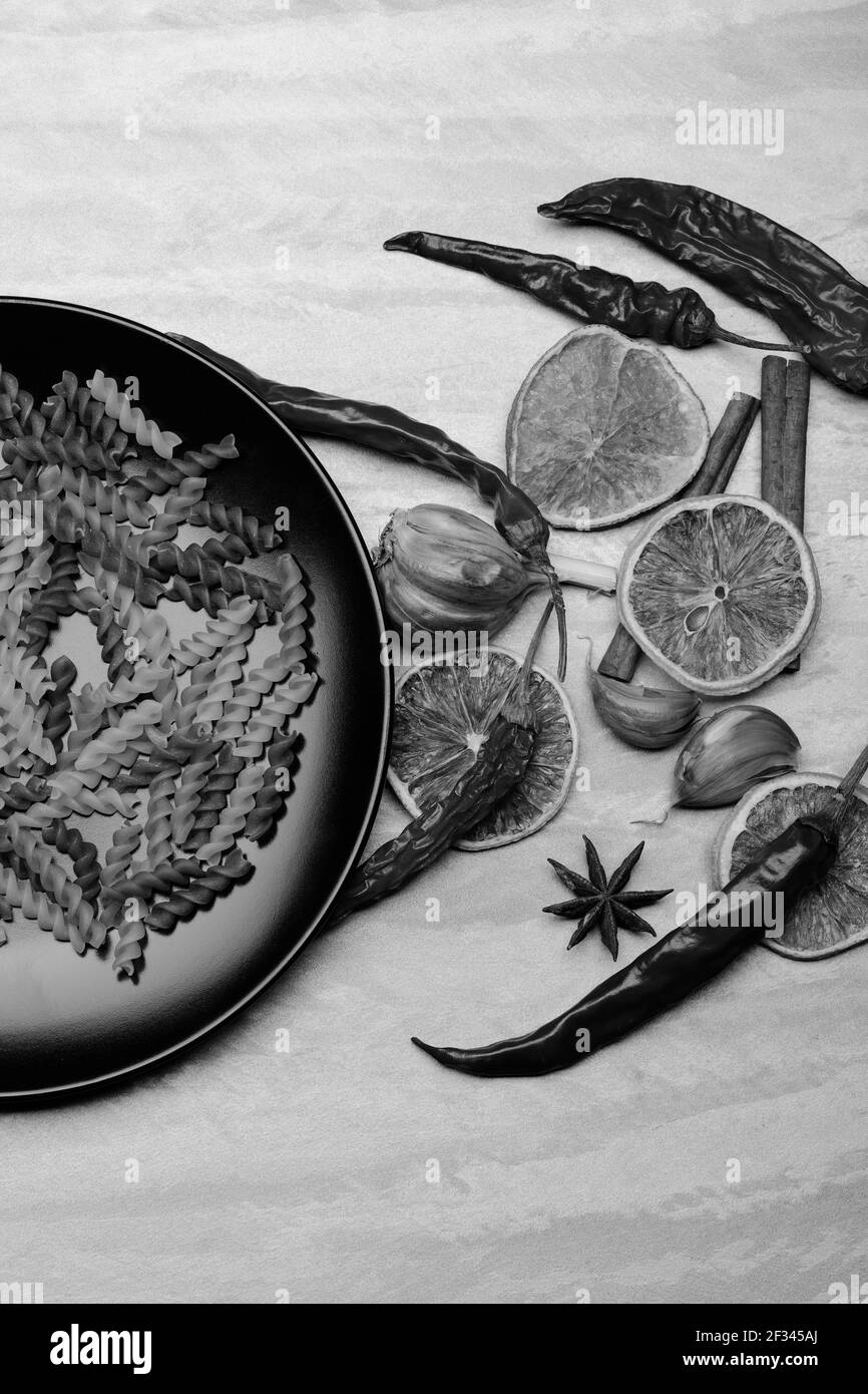 italian pasta in black ceramic plate with ingredients for cooking Stock ...