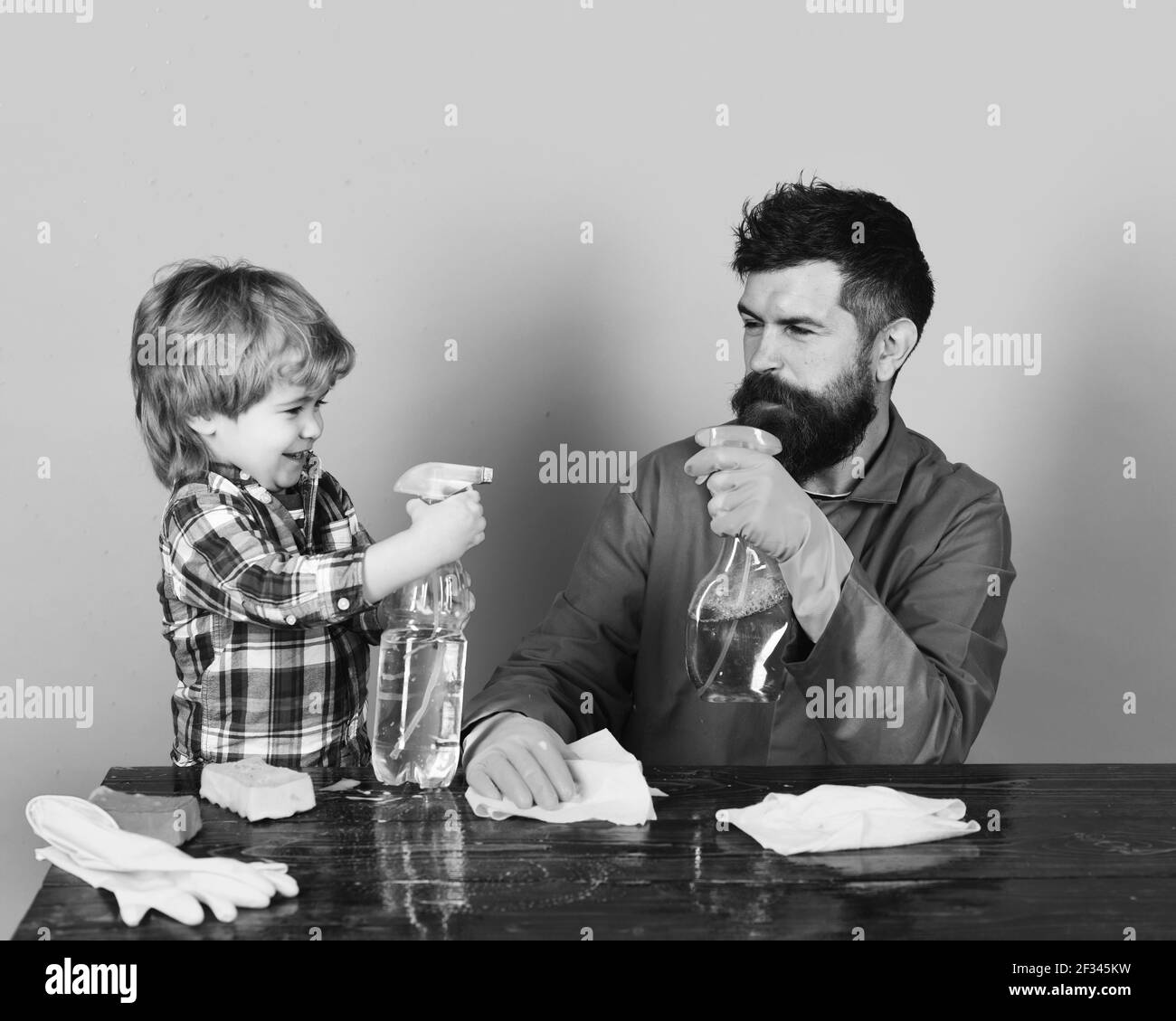 Dad and son plays with cleaning props on blue background. Kid with ...