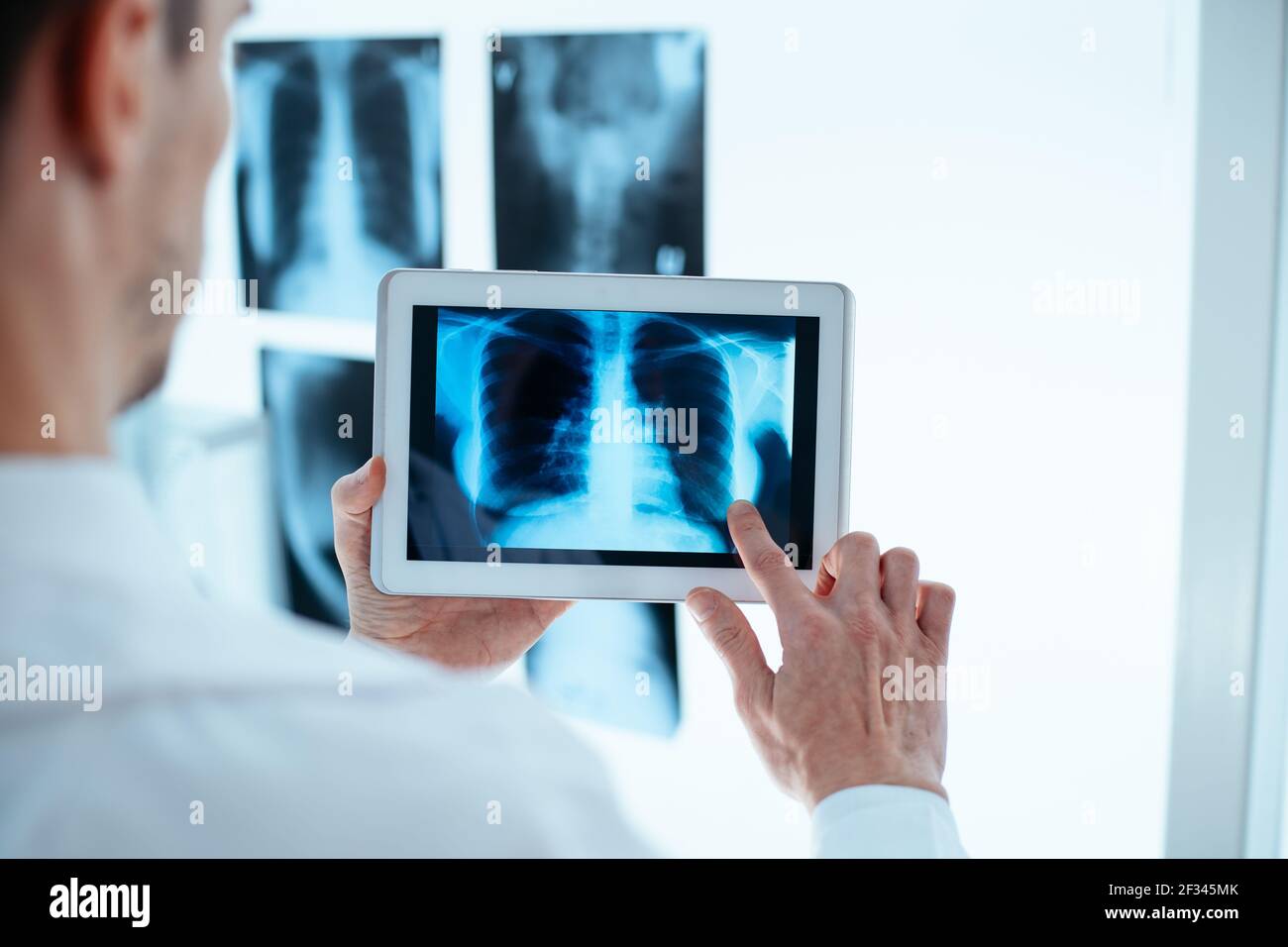 Doctor examining x-ray of chest and ribs on digital tablet Stock Photo ...
