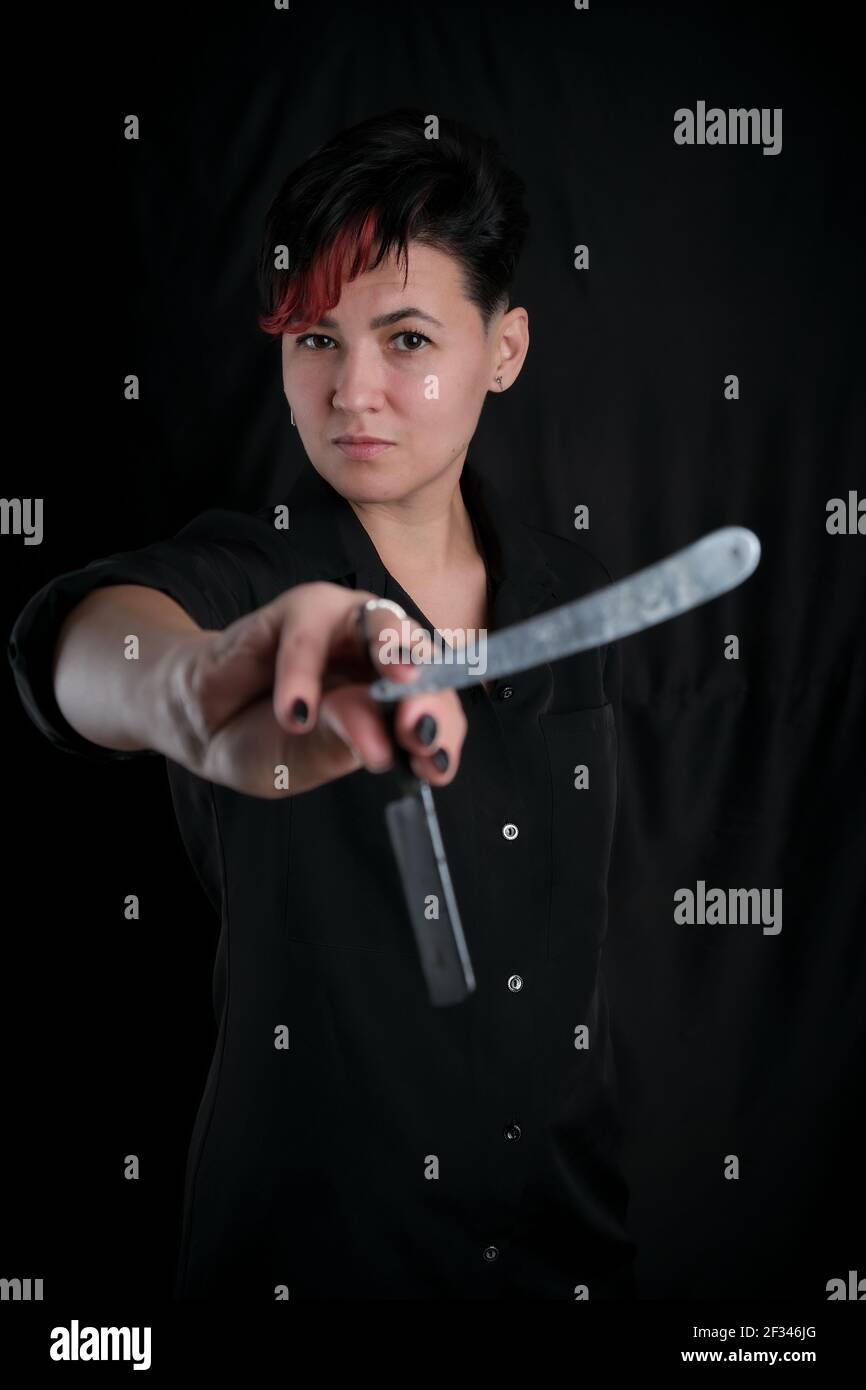 Half length portrait of young adult barber woman on black background ...